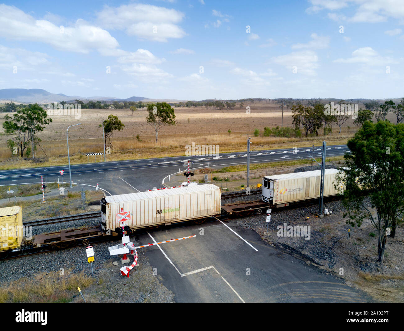 Aerial of mixed freight train passing through a boom controlled level ...