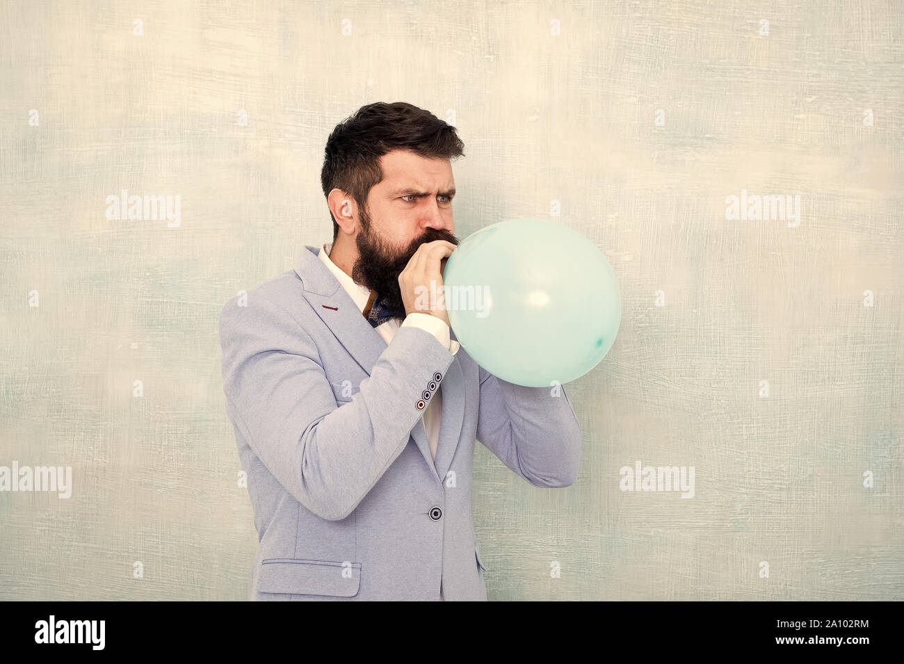 Man inflating a blue balloon. Bearded man with balloon. Happy birthday ...