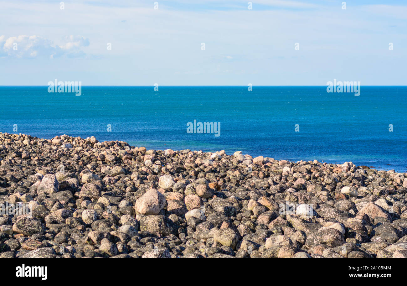 Just rocks and a calm sea. Round stones washed by the waters of the ...