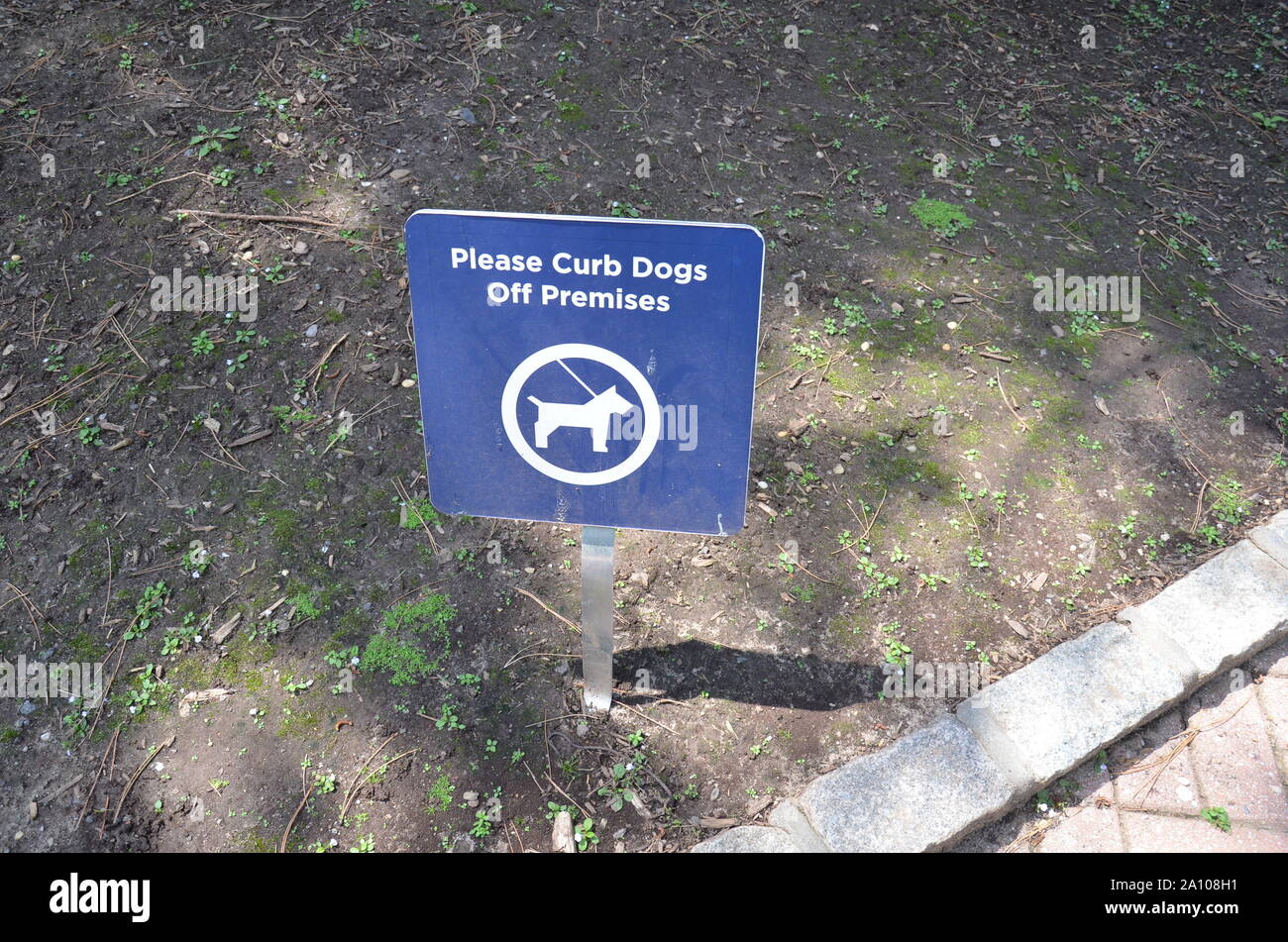 blue please curb dog off of premises sign in dirt Stock Photo - Alamy