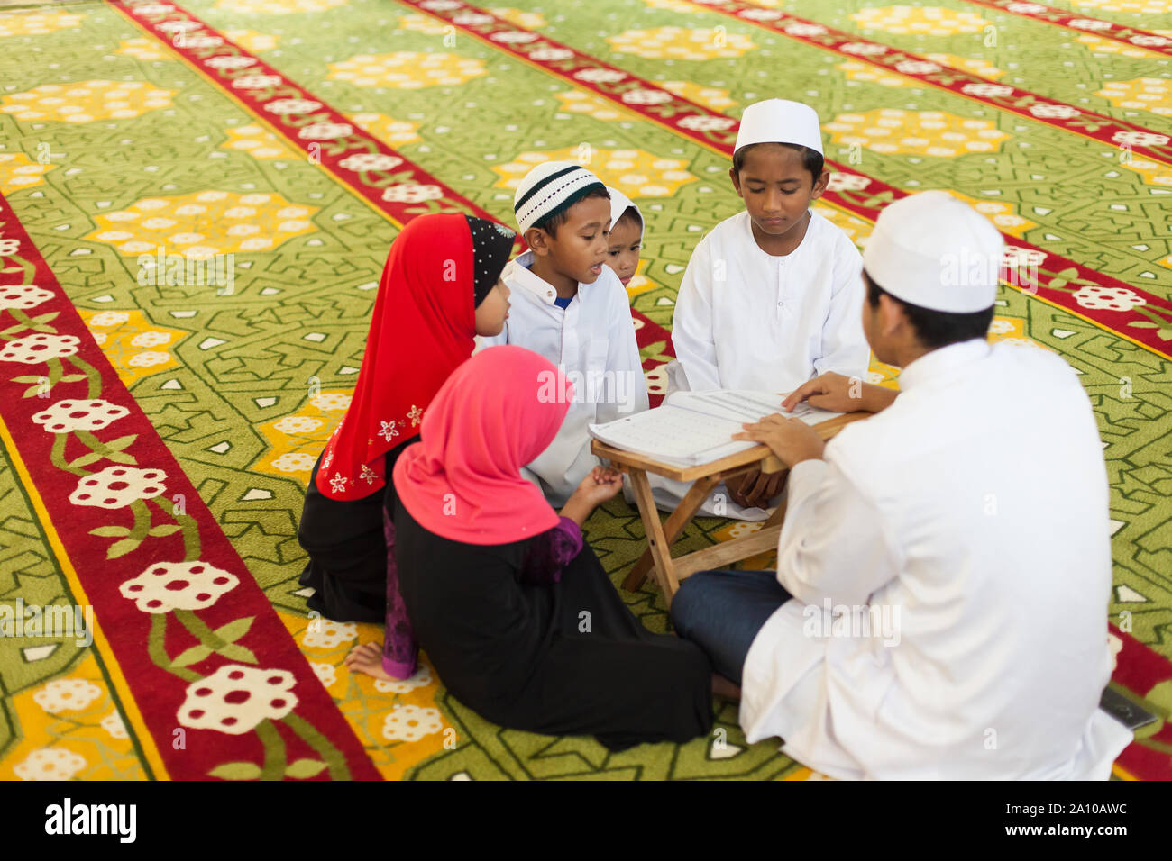 A group of young boys and girls studying inside Masjid Sultan Mosque ...