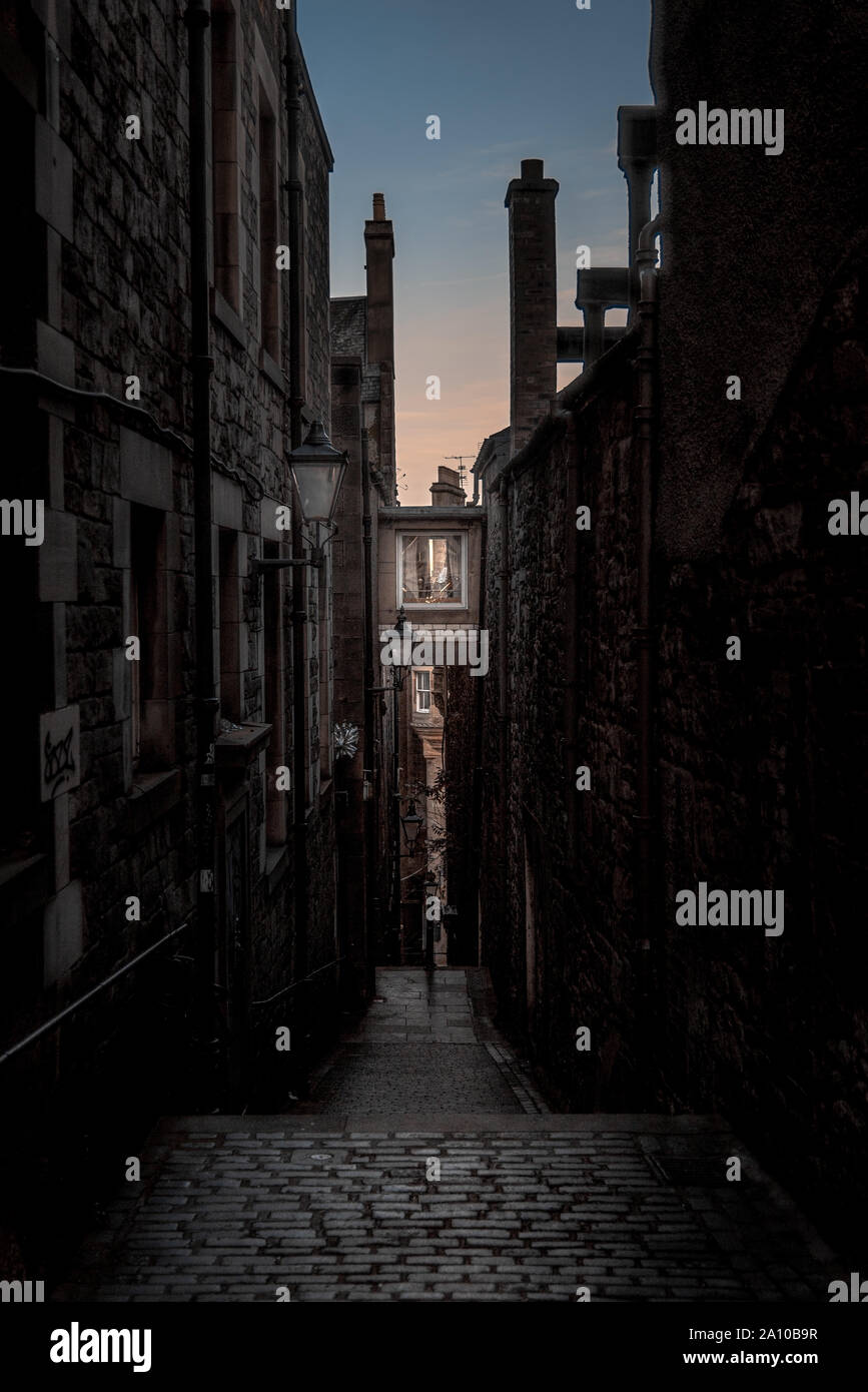 Narrow European alley, surrounded by bricks and cobblestone ...