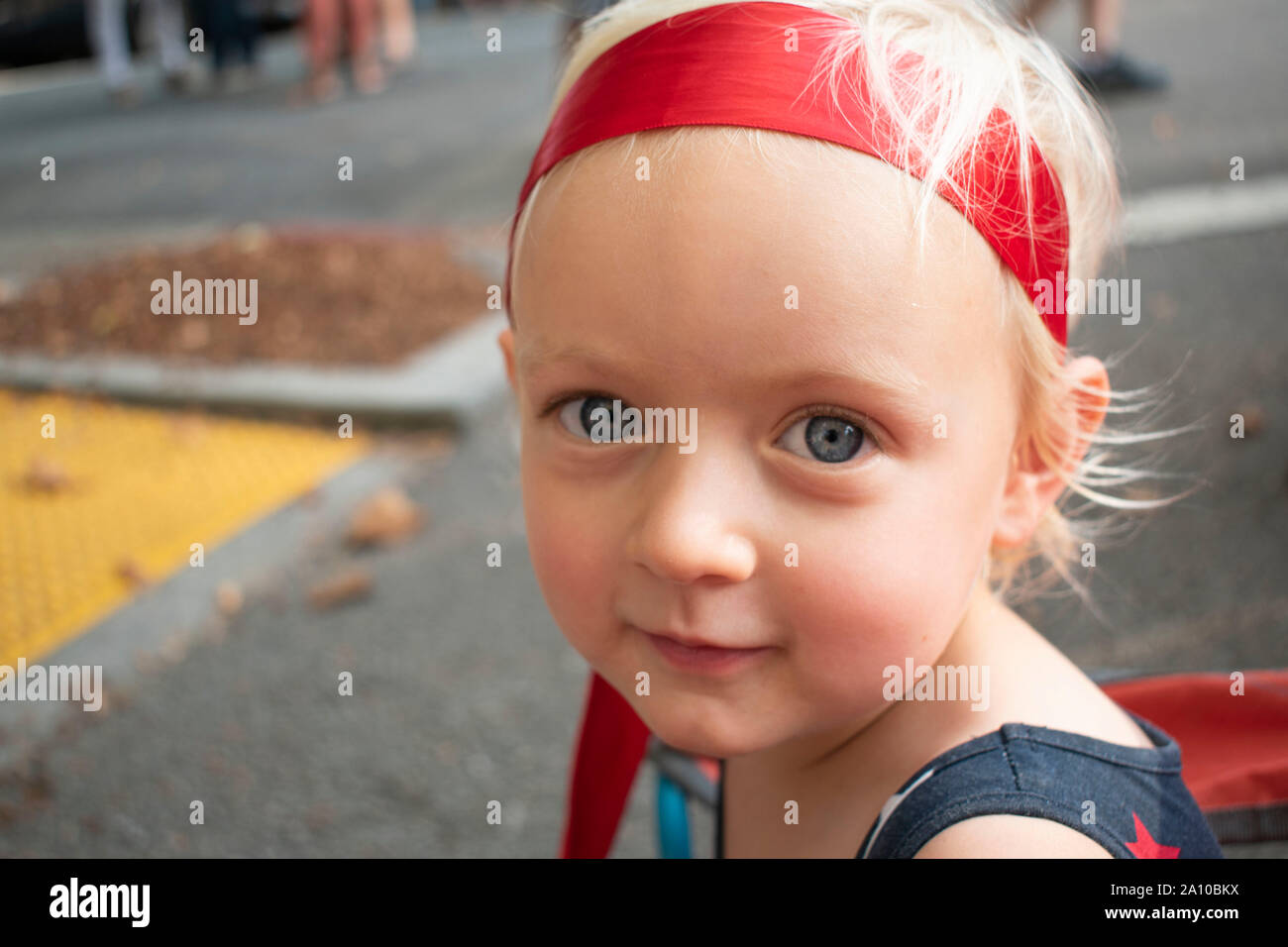 A young girl plays around with the ribbon on her head during a music ...
