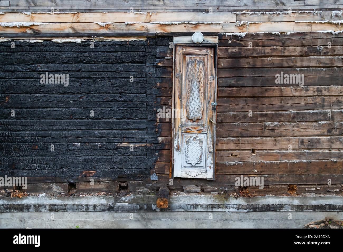 The wall of a wooden house made of timber is half burned up after a ...