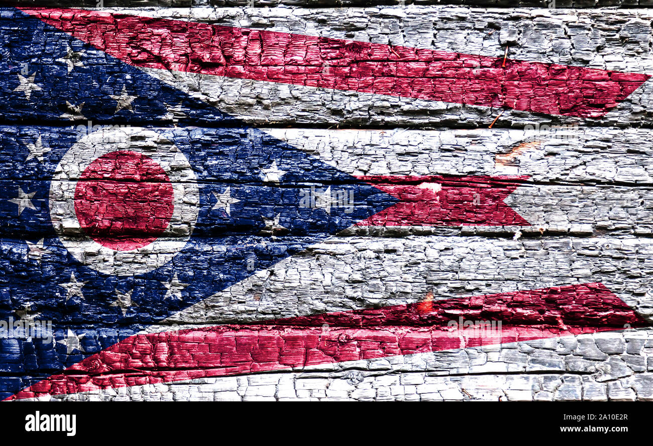 The national flag of the US state Ohio in against a black charred ...