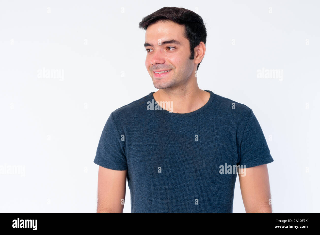 Face of happy young handsome Persian man thinking and looking away ...