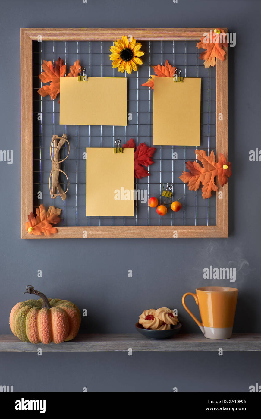 Photo grid board with decorative Autumn leaves. Orange cup, cookies and ...