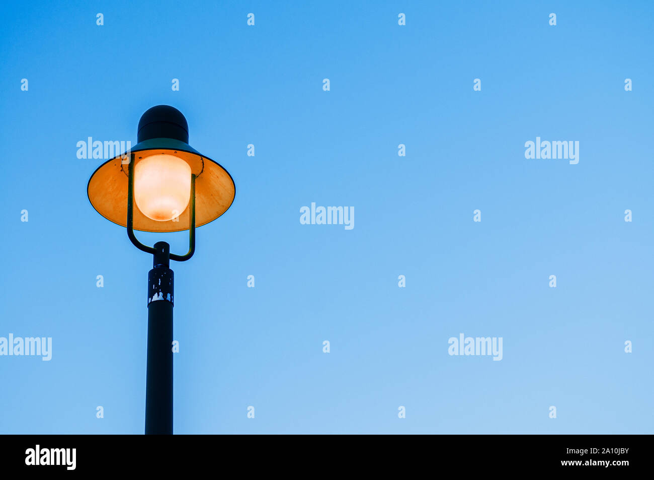 Vintage retro electric light pole with blue evening sky background with ...