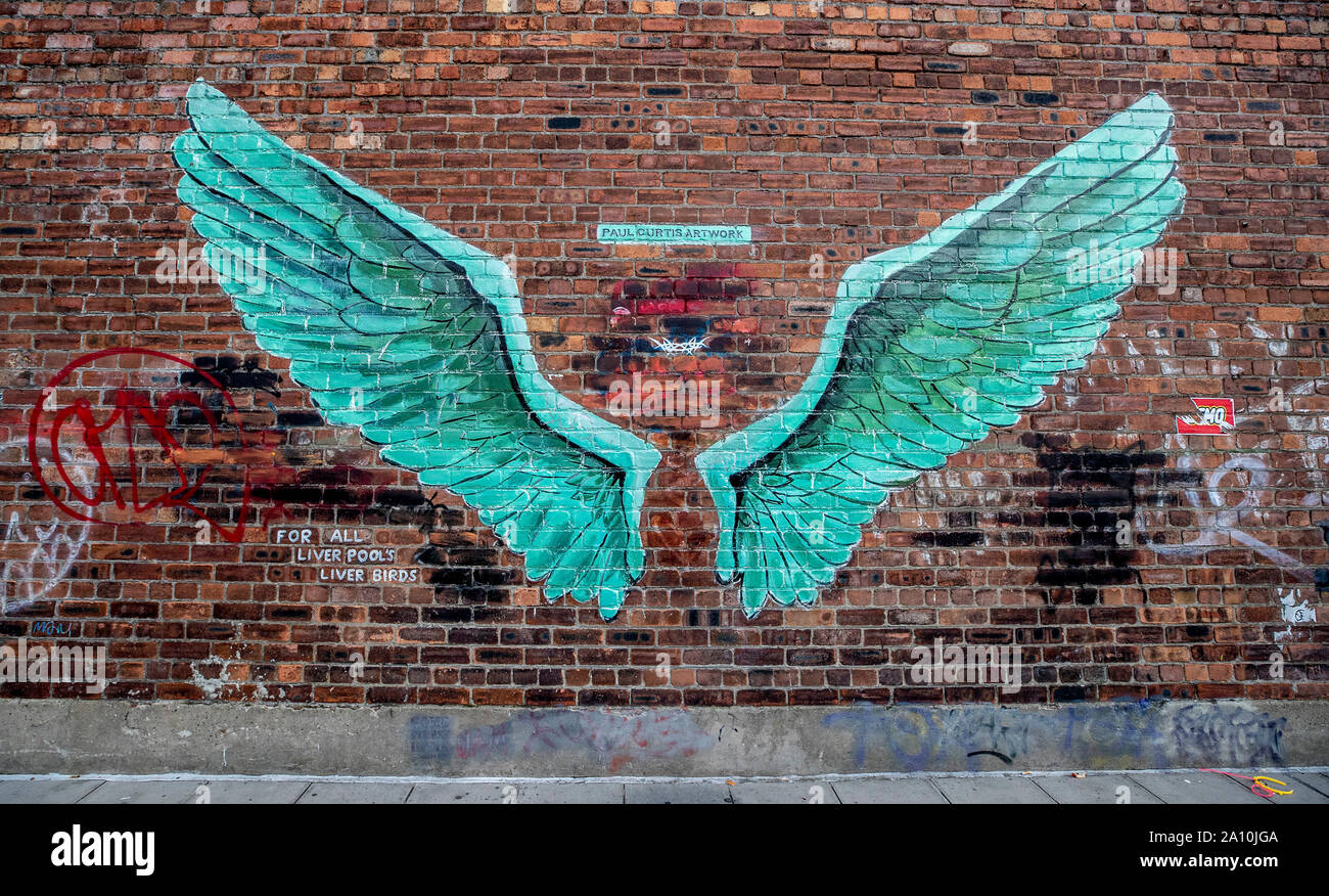 A pair of large liver bird wings painted on the side of a building in ...