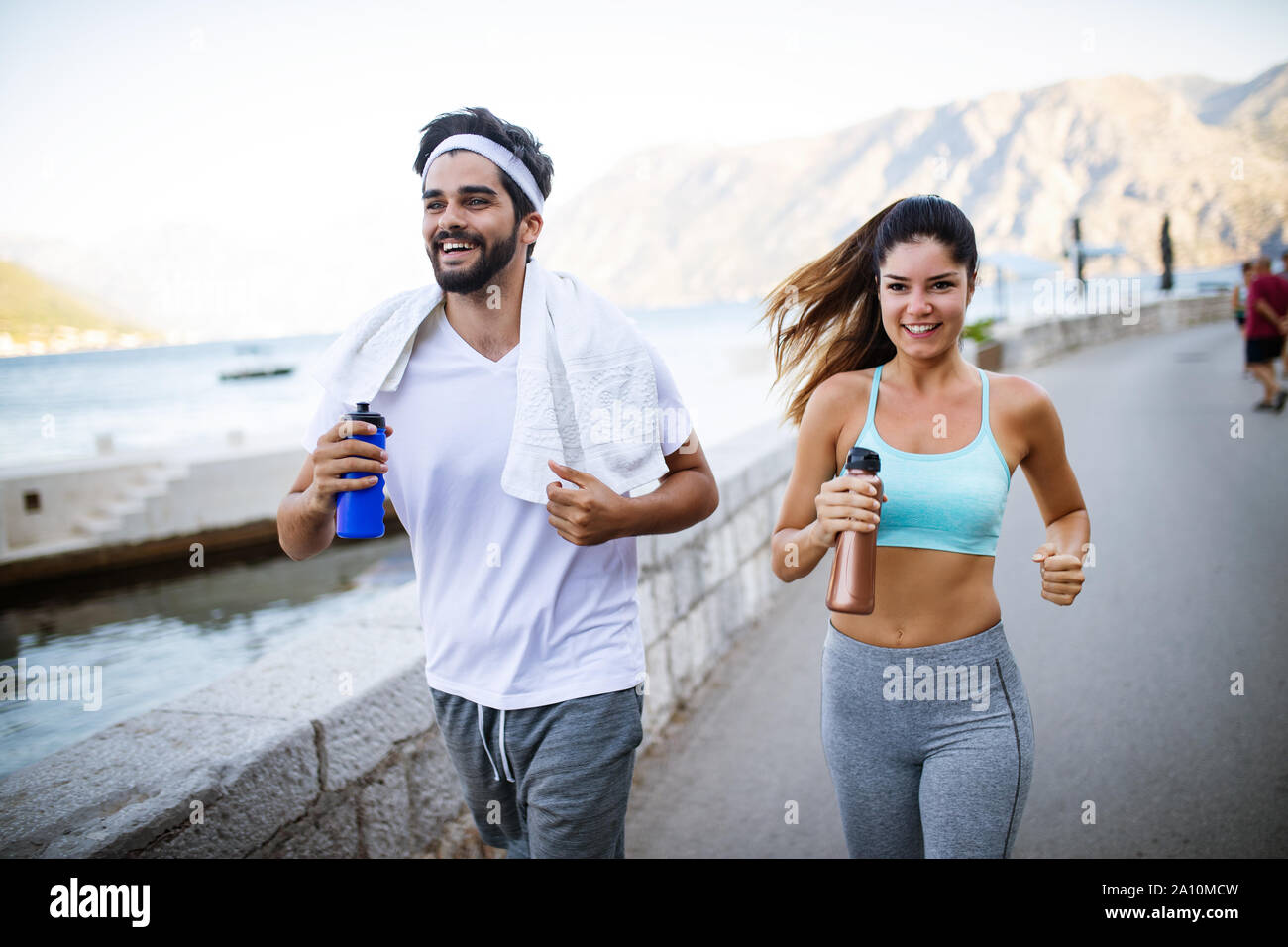 Happy young fit people couple running outdoor Stock Photo - Alamy