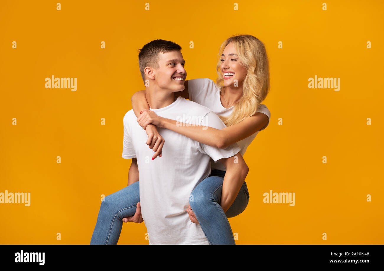 Young guy giving piggyback ride to his girlfriend Stock Photo - Alamy