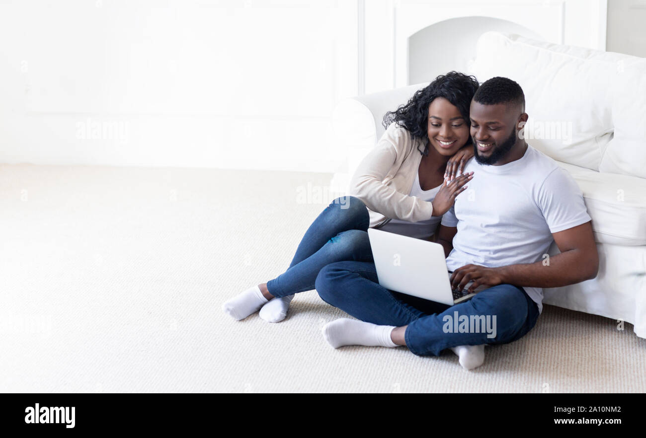 African american couple sitting on floor with laptop Stock Photo - Alamy