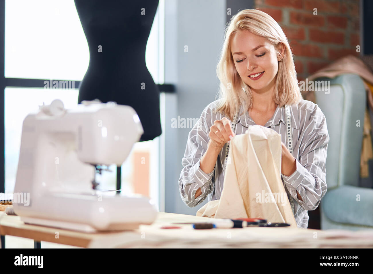 attractive hardworking dressmaker embroiders a cloth. close up photo ...
