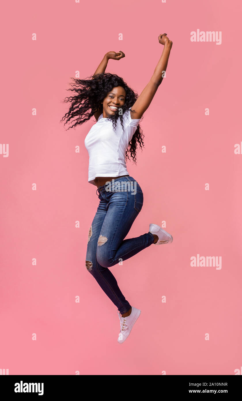 Smiling young african woman jumping in air Stock Photo - Alamy