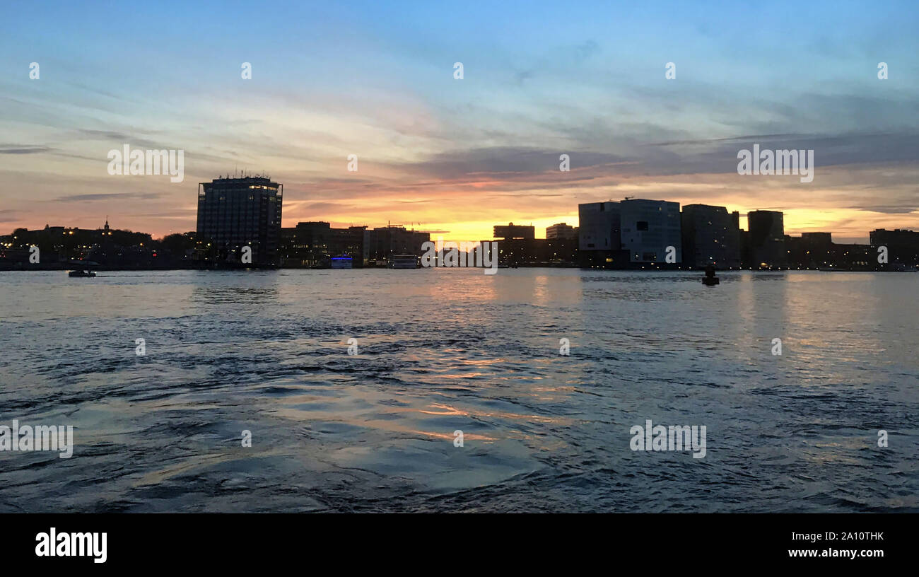 sunset over the skyline of the old city of amsterdam with ADAM tower at ...