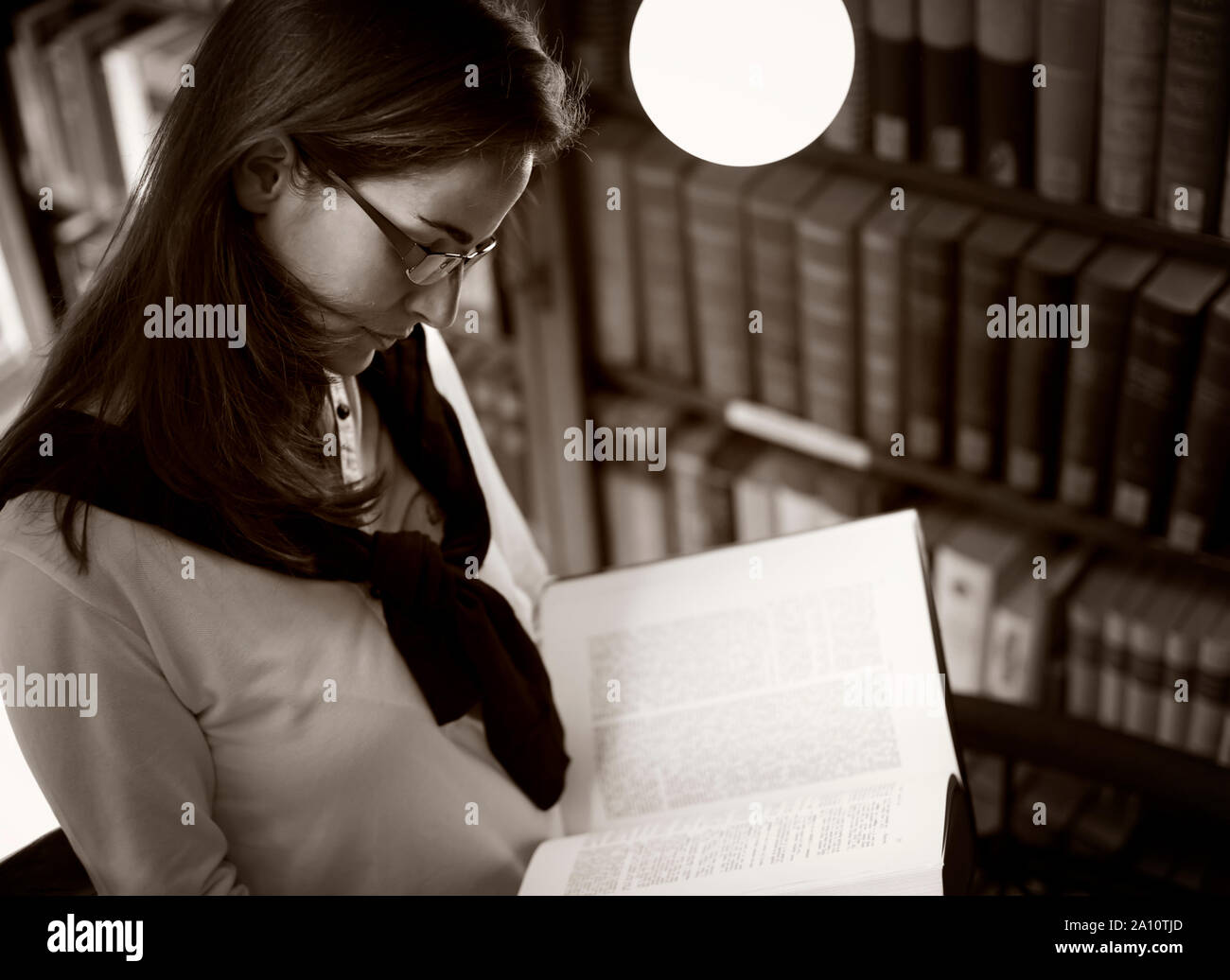 Student reading at bookshelf Stock Photo - Alamy