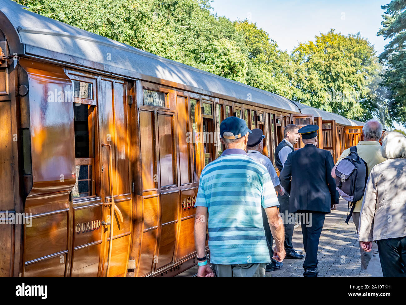 Passengers boarding the traditional wooden train carriage at Holt train ...