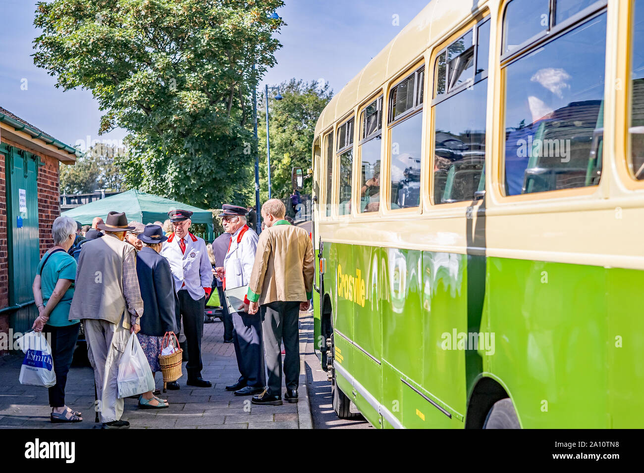 group of people in 1940s dress queuing for a classic forties bus during ...