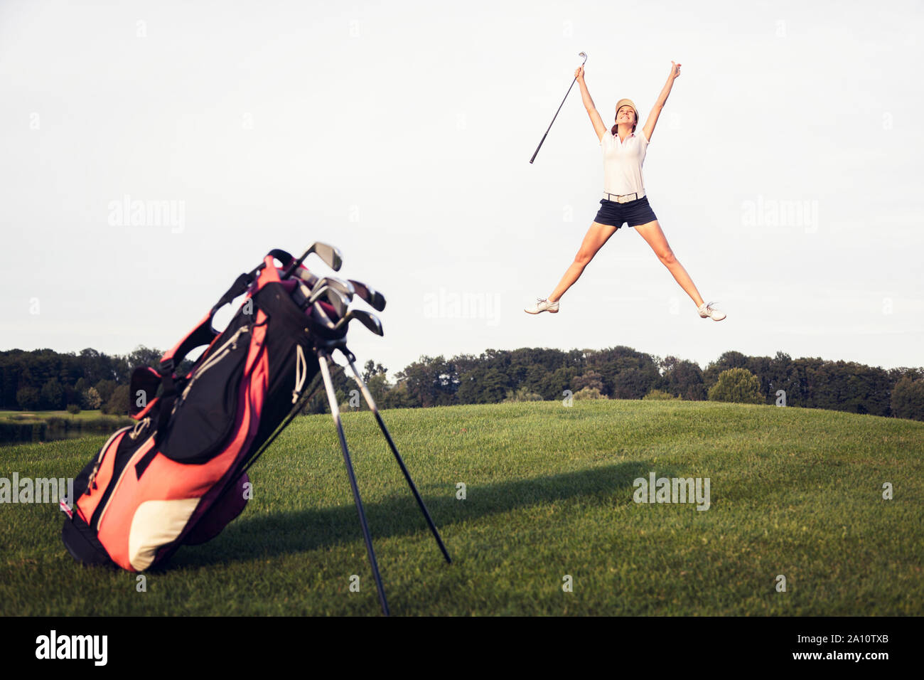 Happy golf player jumping on golf course Stock Photo - Alamy