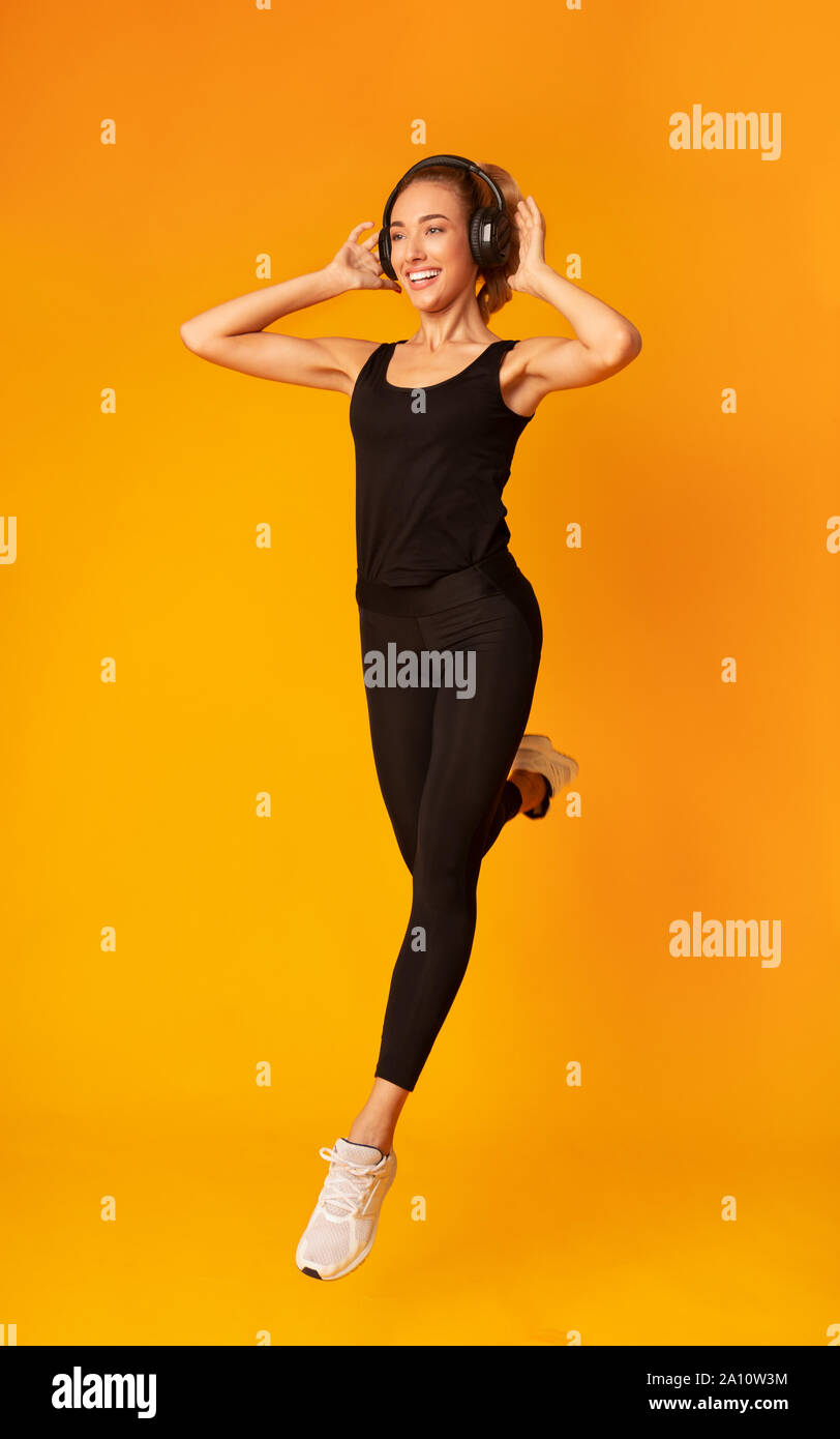 Happy Woman In Headphones Running To The Gym, Yellow Background Stock ...