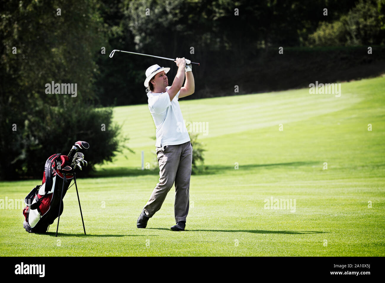 Golfer pitching at golf course Stock Photo - Alamy