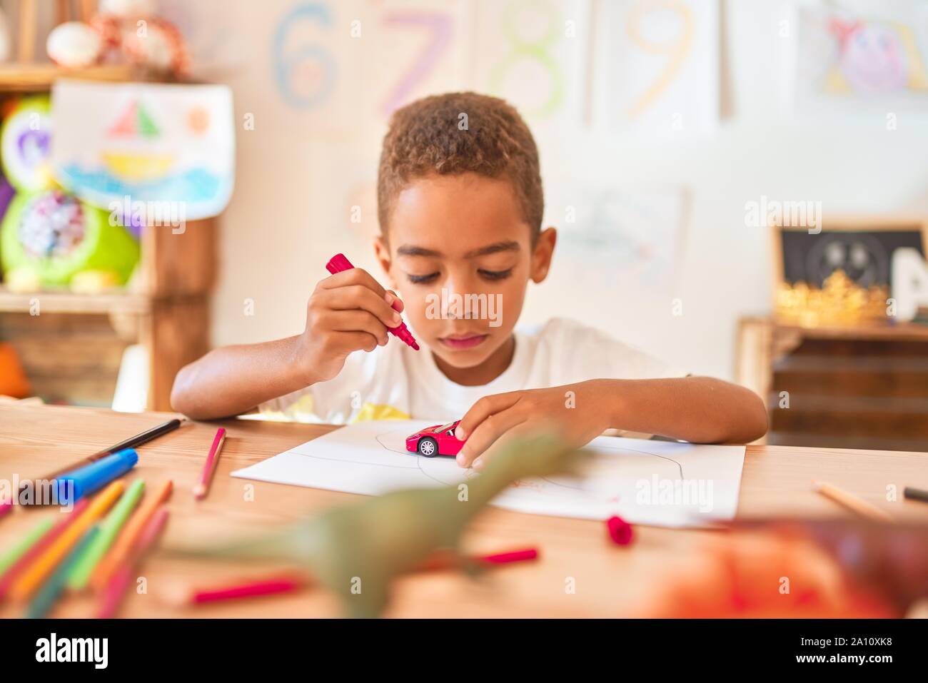Beautiful african american toddler sitting painting car toy using ...