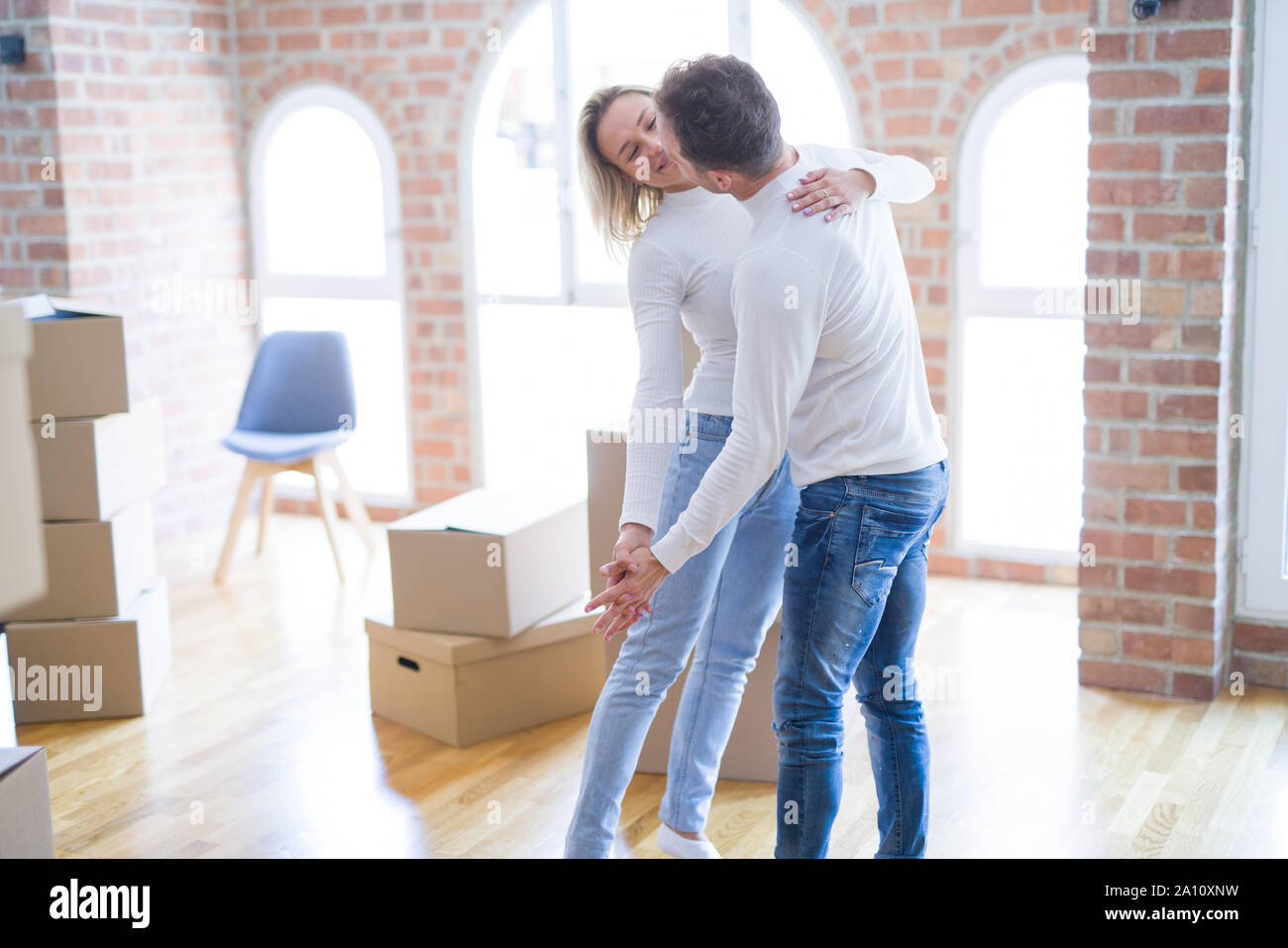 Young beautiful couple dancing at new home around cardboard boxes Stock ...