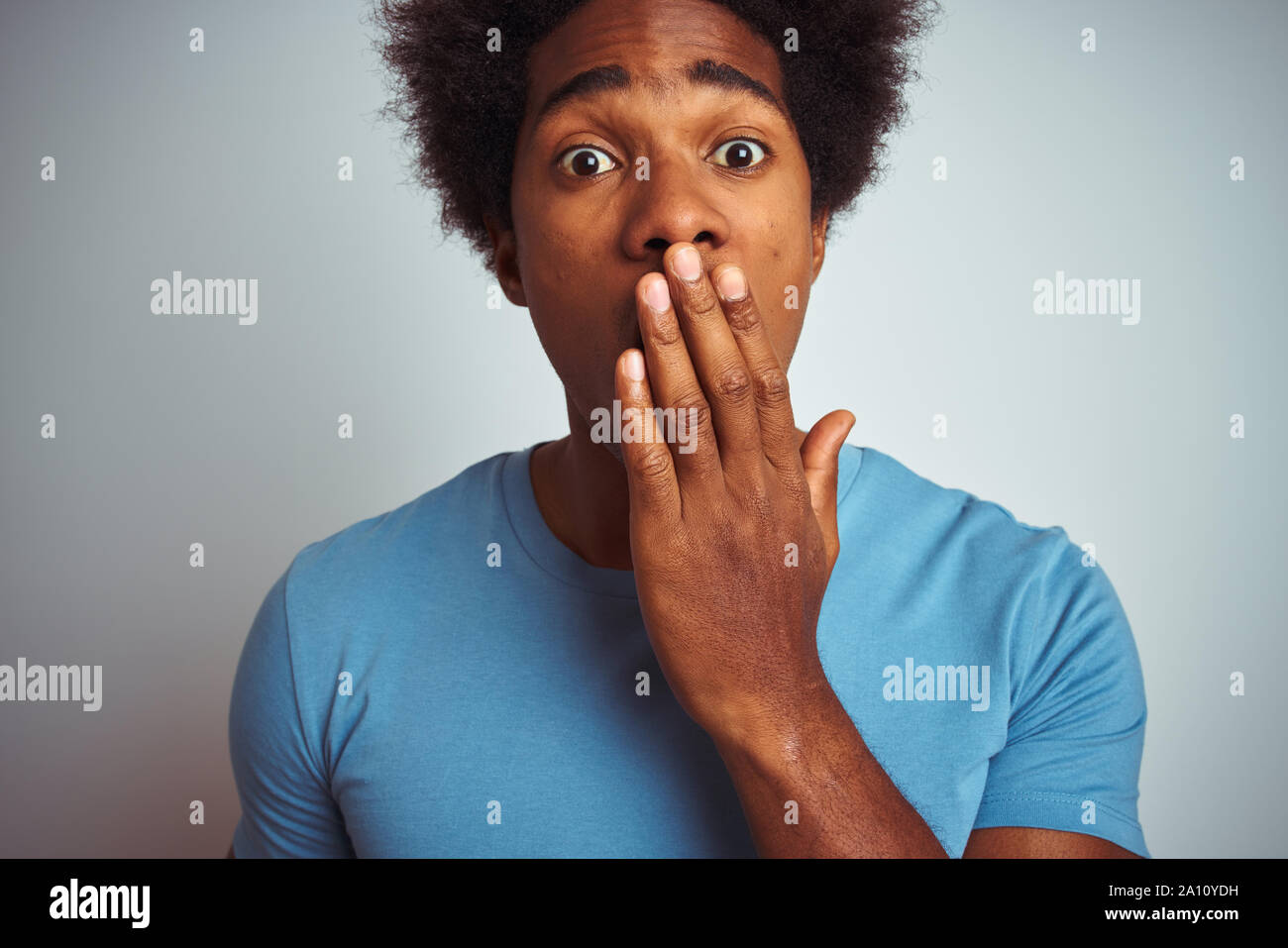 African american man with afro hair wearing blue t-shirt standing over ...