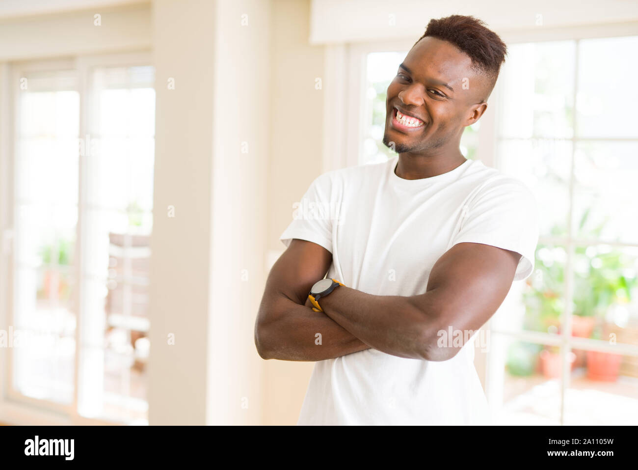 Handsome african young man smiling cheerful with crossed arms Stock ...