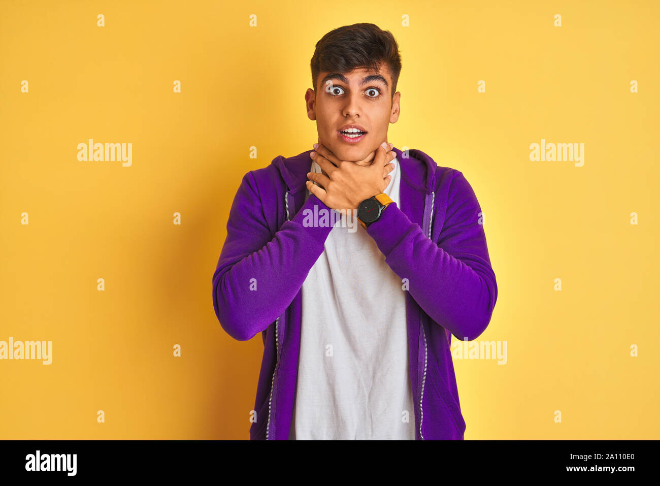 Young indian man wearing purple sweatshirt standing over isolated ...