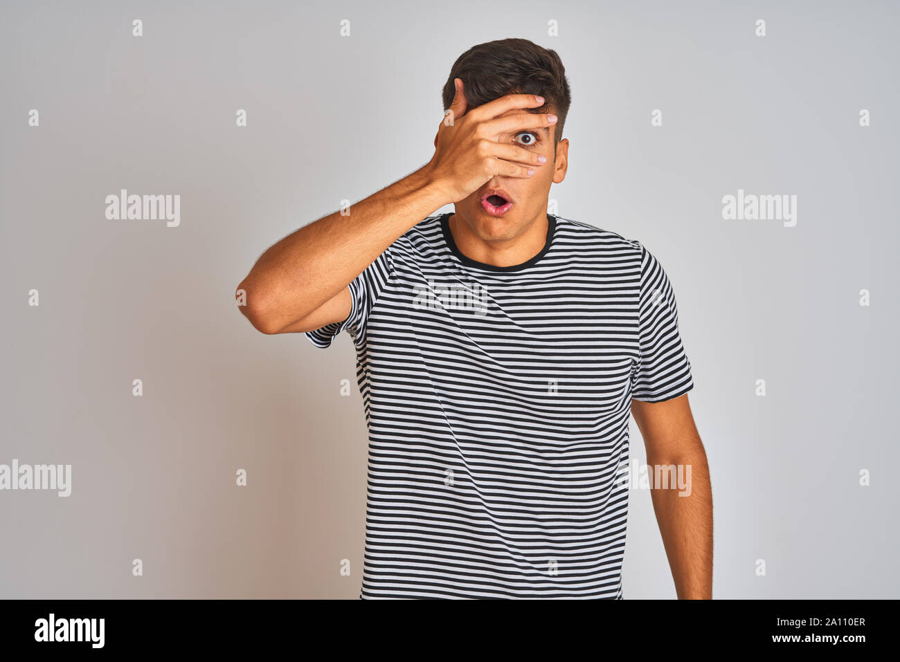 Young indian man wearing navy striped t-shirt standing over isolated ...