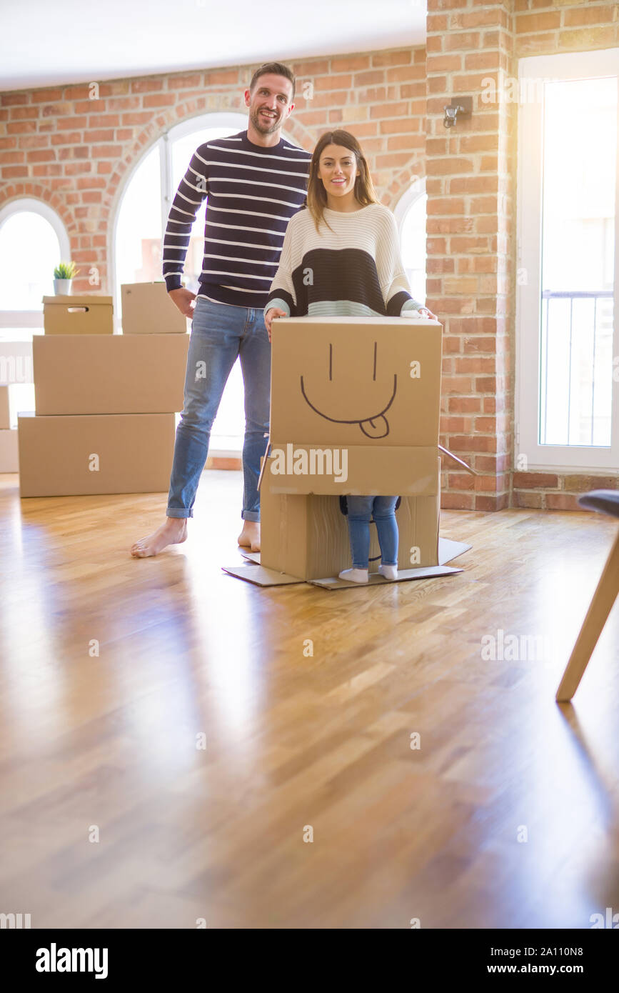 Beautiful famiily with kid playing with cardboard fanny boxes at new ...