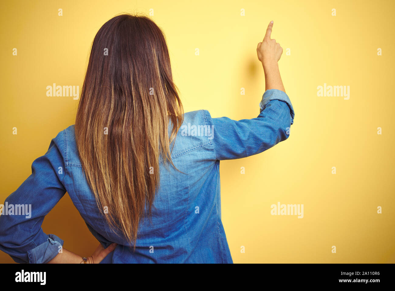 Young beautiful woman standing over yellow isolated background Posing ...