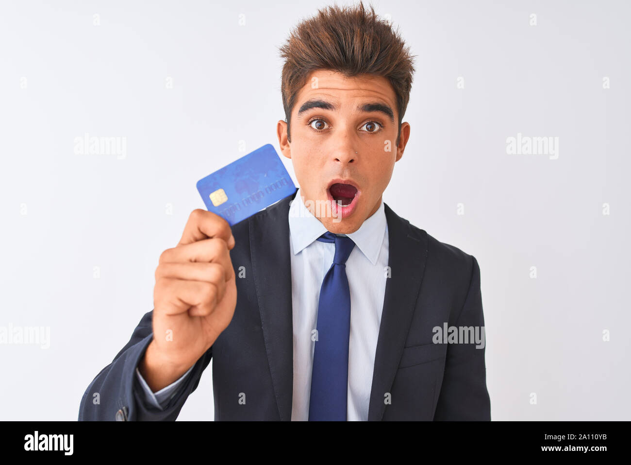 Young handsome businessman wearing suit holding credit card over ...