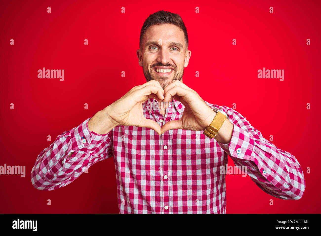 Young handsome man over red isolated background smiling in love doing ...