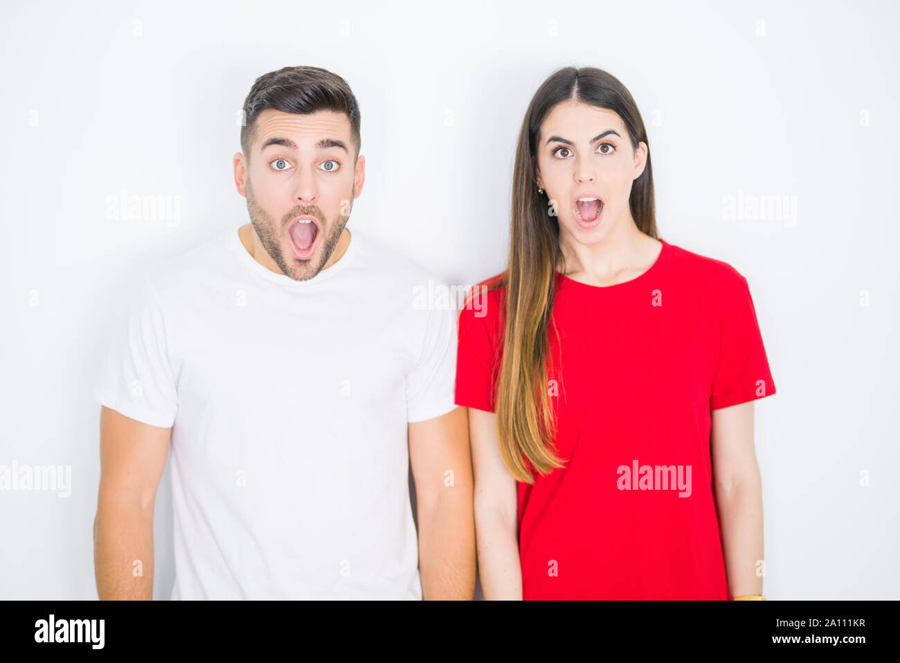 Young beautiful couple together over white isolated background afraid ...