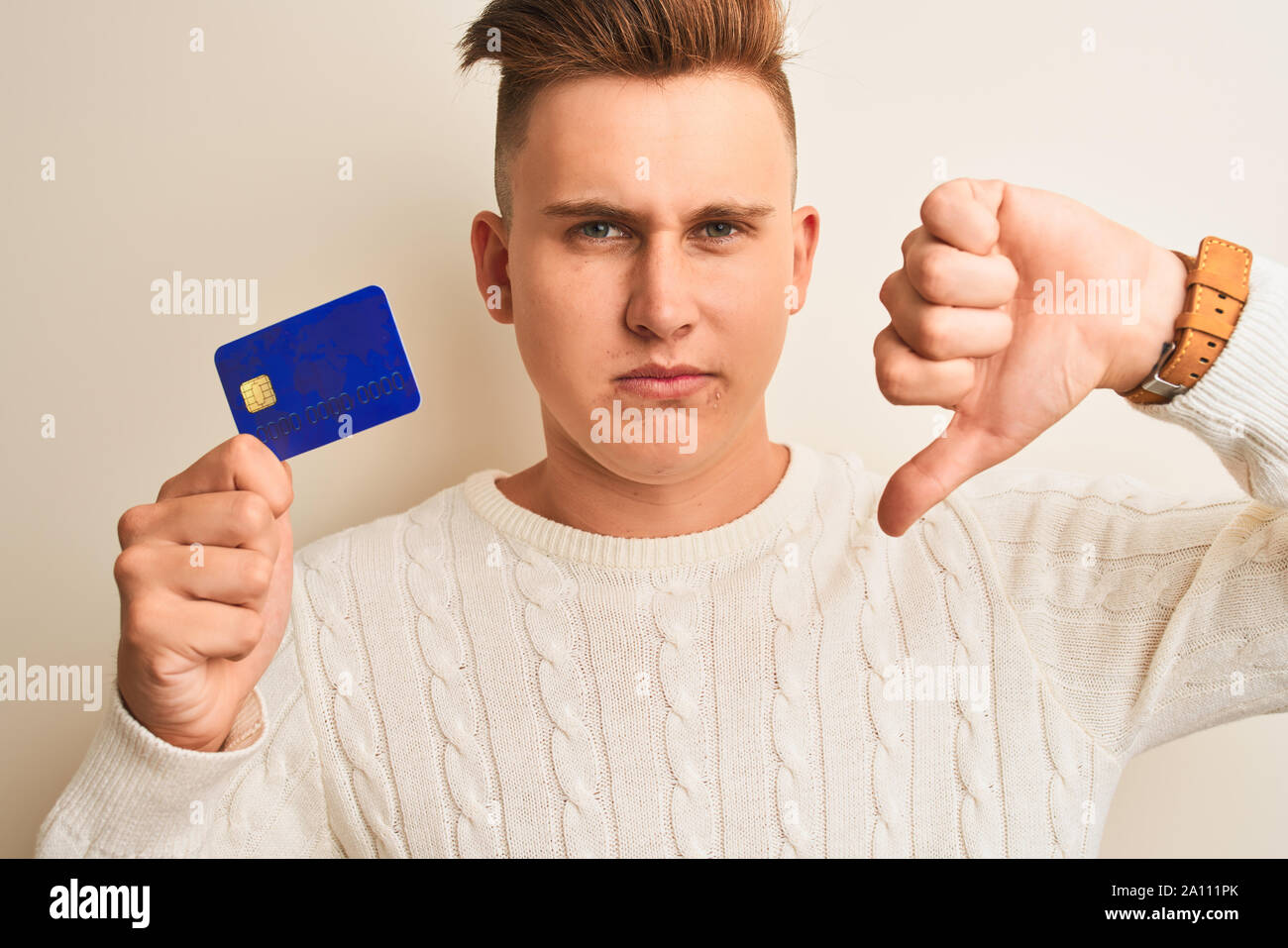 Young handsome man holding credit card over isolated white background ...