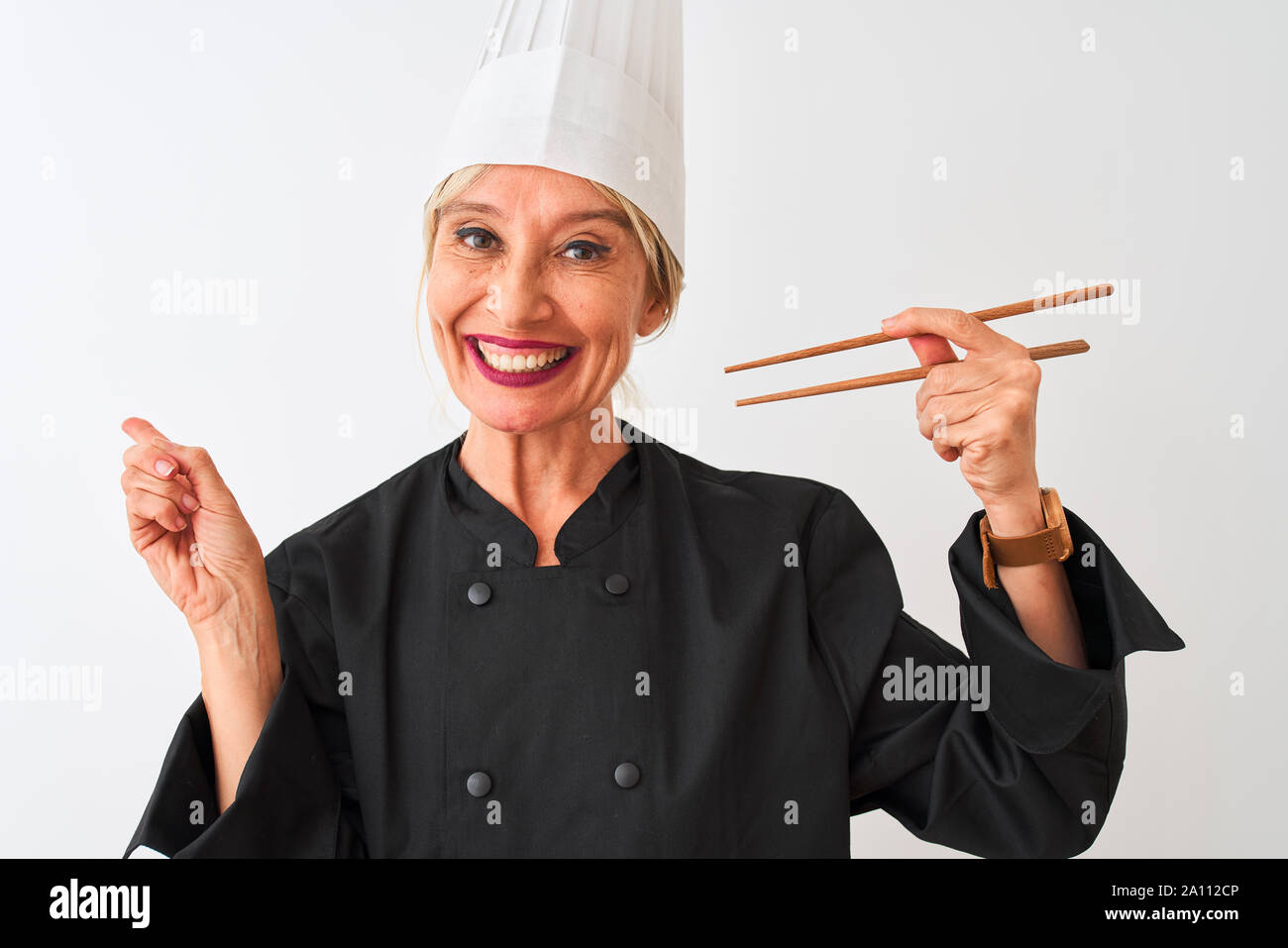 Middle age chef woman wearing cap holding chopsticks over isolated ...