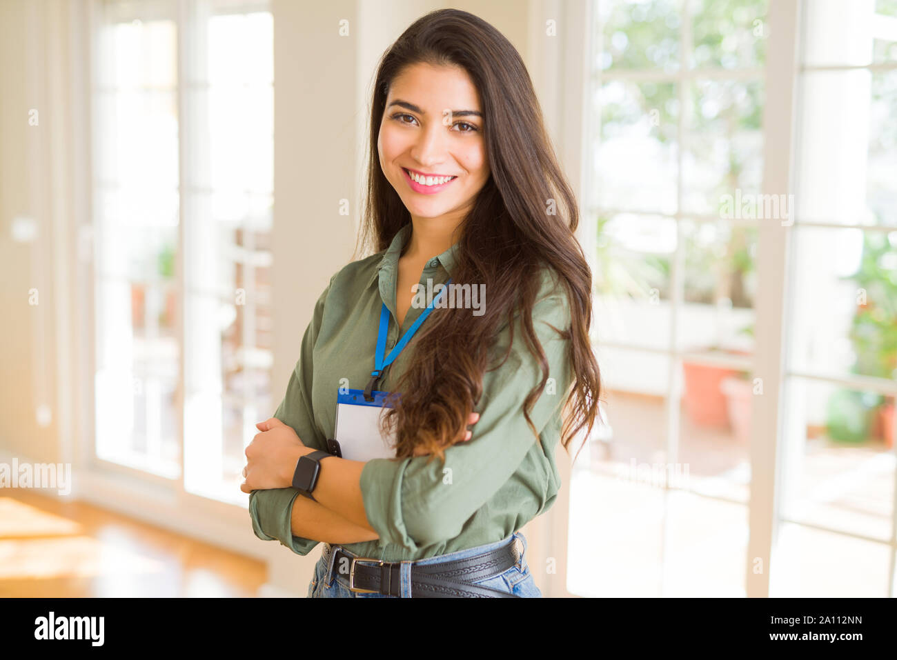 Young beautiful business woman wearing id card and smiling confident ...