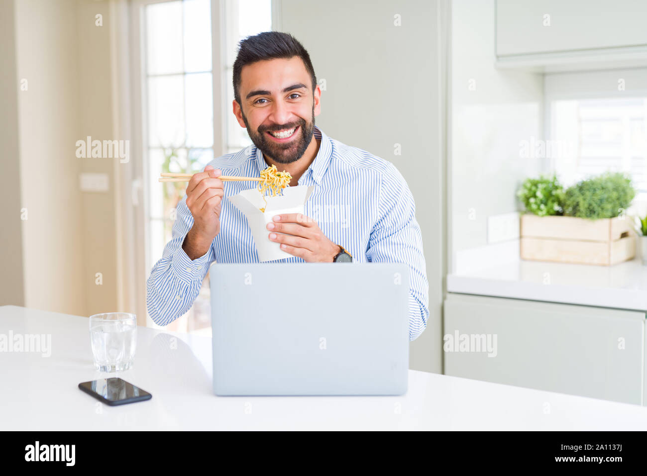 Business man eating asian food from delivery while working using ...