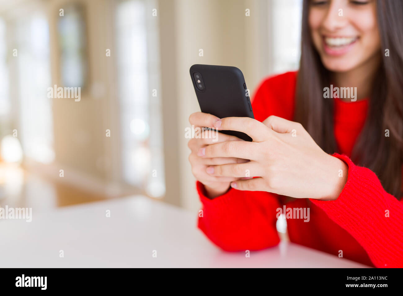 Young woman using smartphone, smiling happy texting and typing Stock ...
