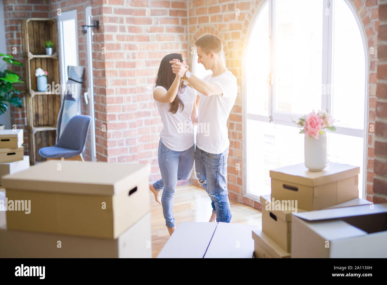 Young beautiful couple dancing at new home around cardboard boxes Stock ...