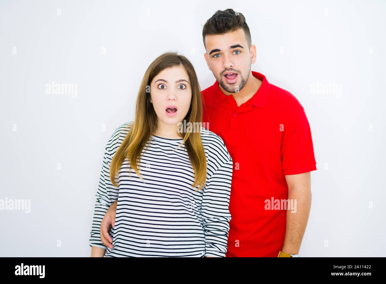 Young beautiful couple together over white isolated background afraid ...