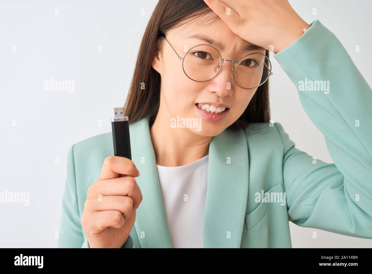 Young chinese businesswoman holding usb memory over isolated white ...