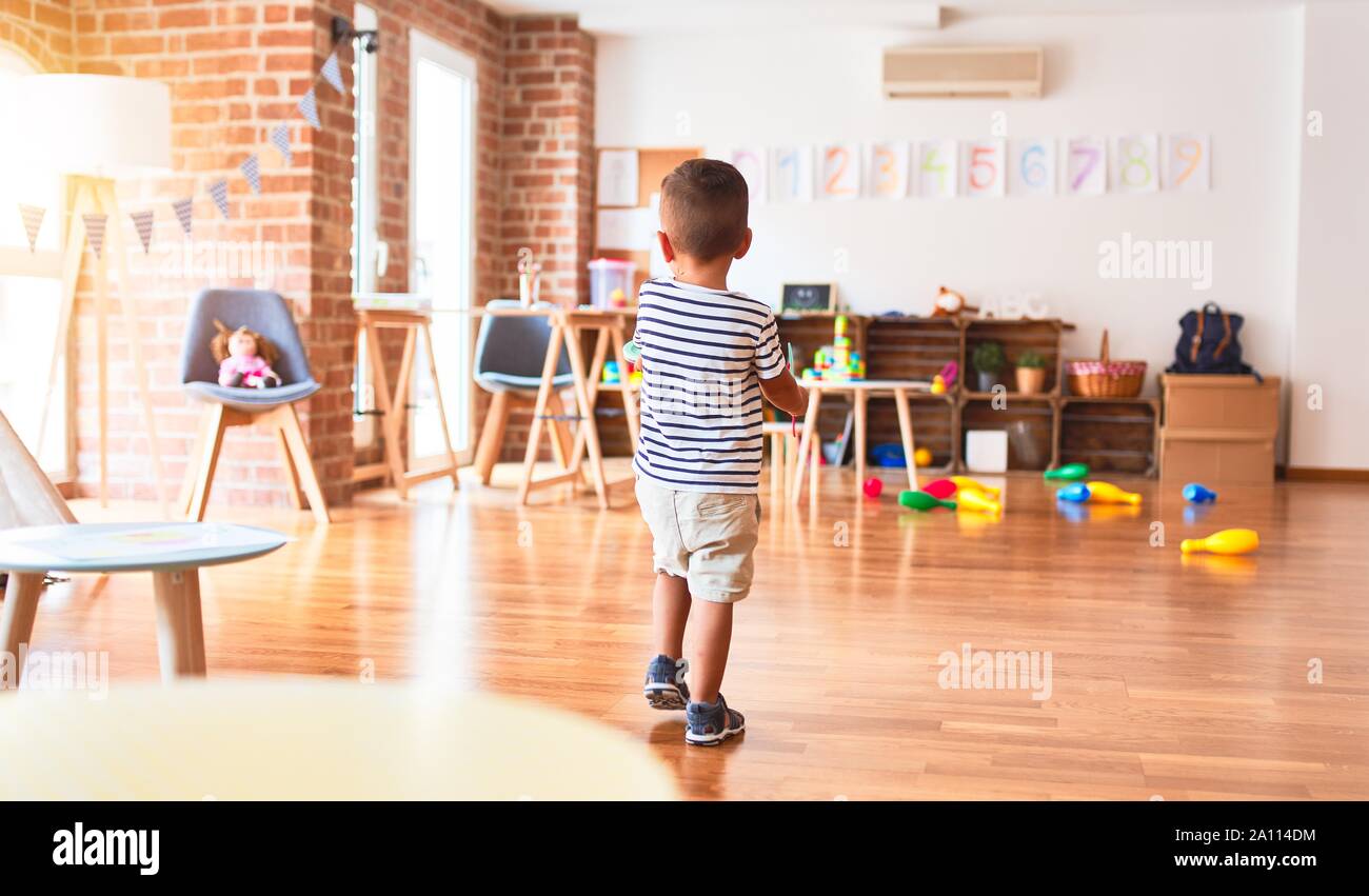 Beautiful toddler boy standing at kindergarten with lots of toys Stock ...