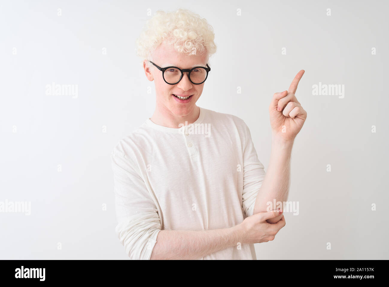Young albino blond man wearing t-shirt and glasses standing over ...