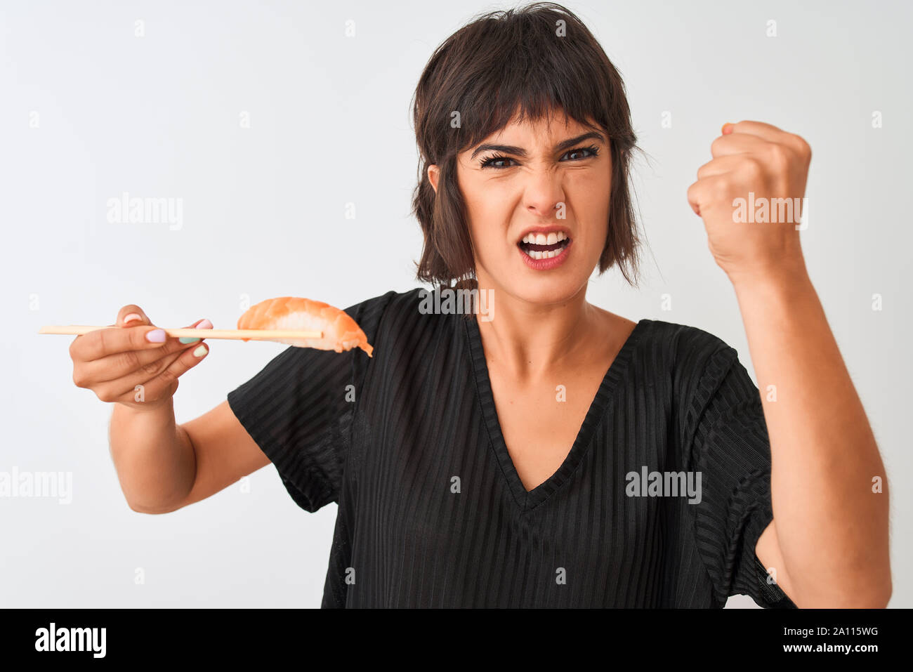 Beautiful woman eating salmon nigiri sushi using chopsticks over ...