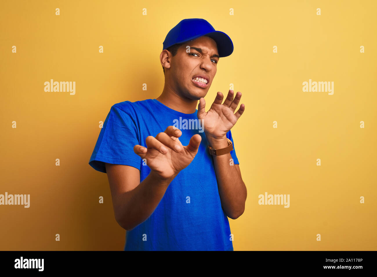 Young handsome arab delivery man standing over isolated yellow ...