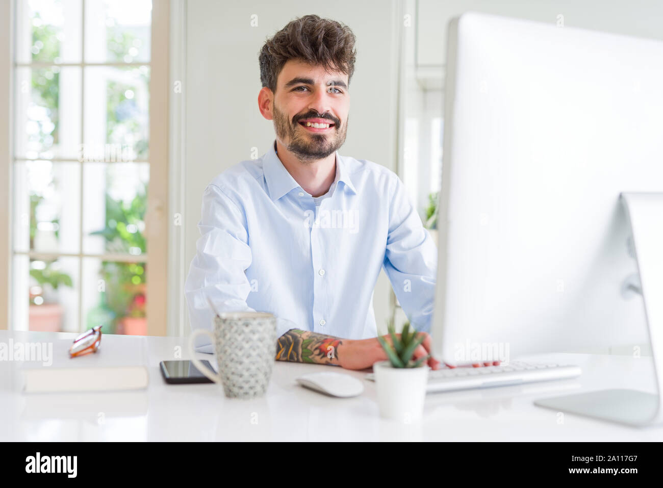 Handsome business young man working using computer, smiling confident ...