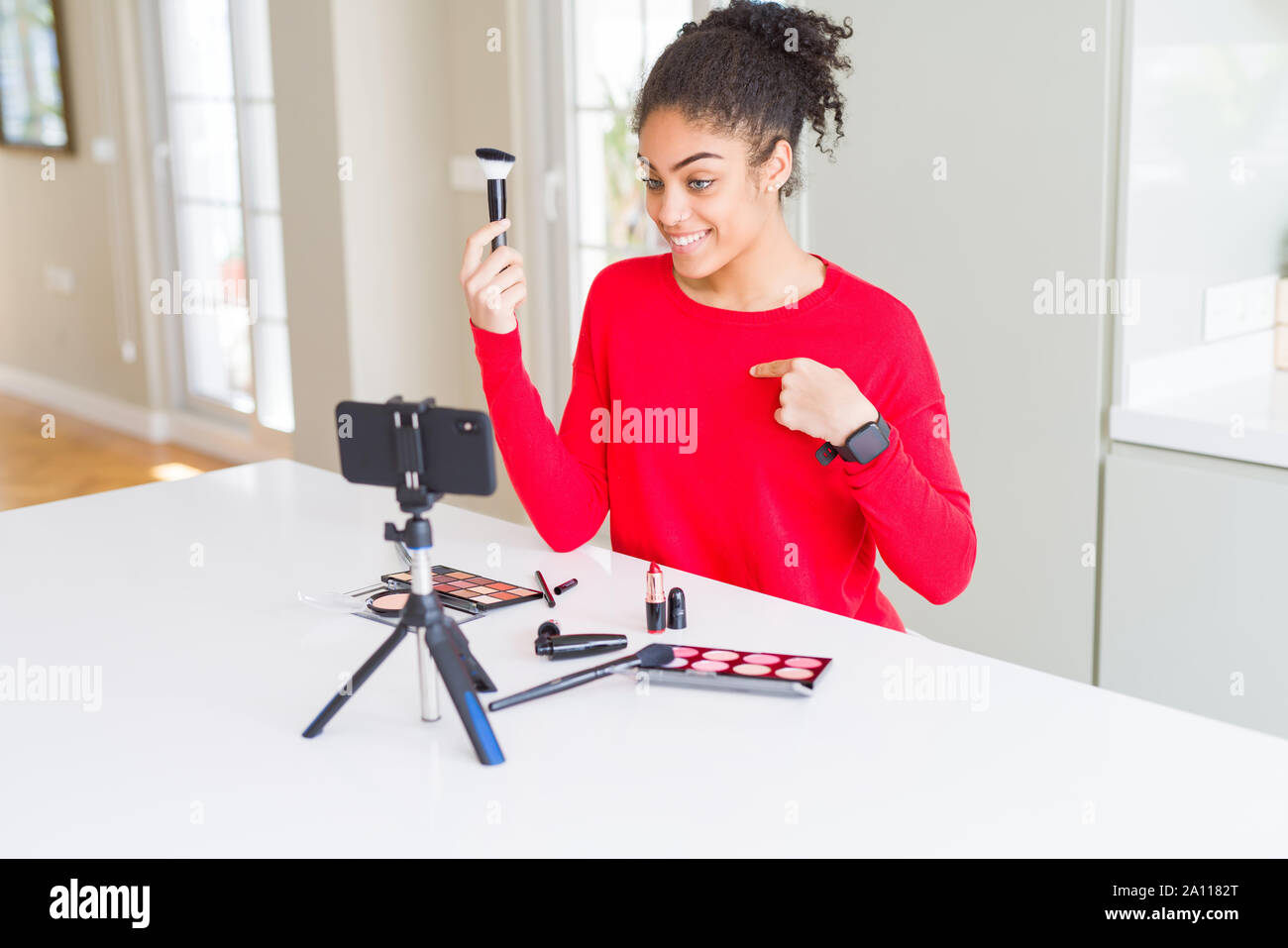 Young african american influencer woman recording make up tutorial with ...
